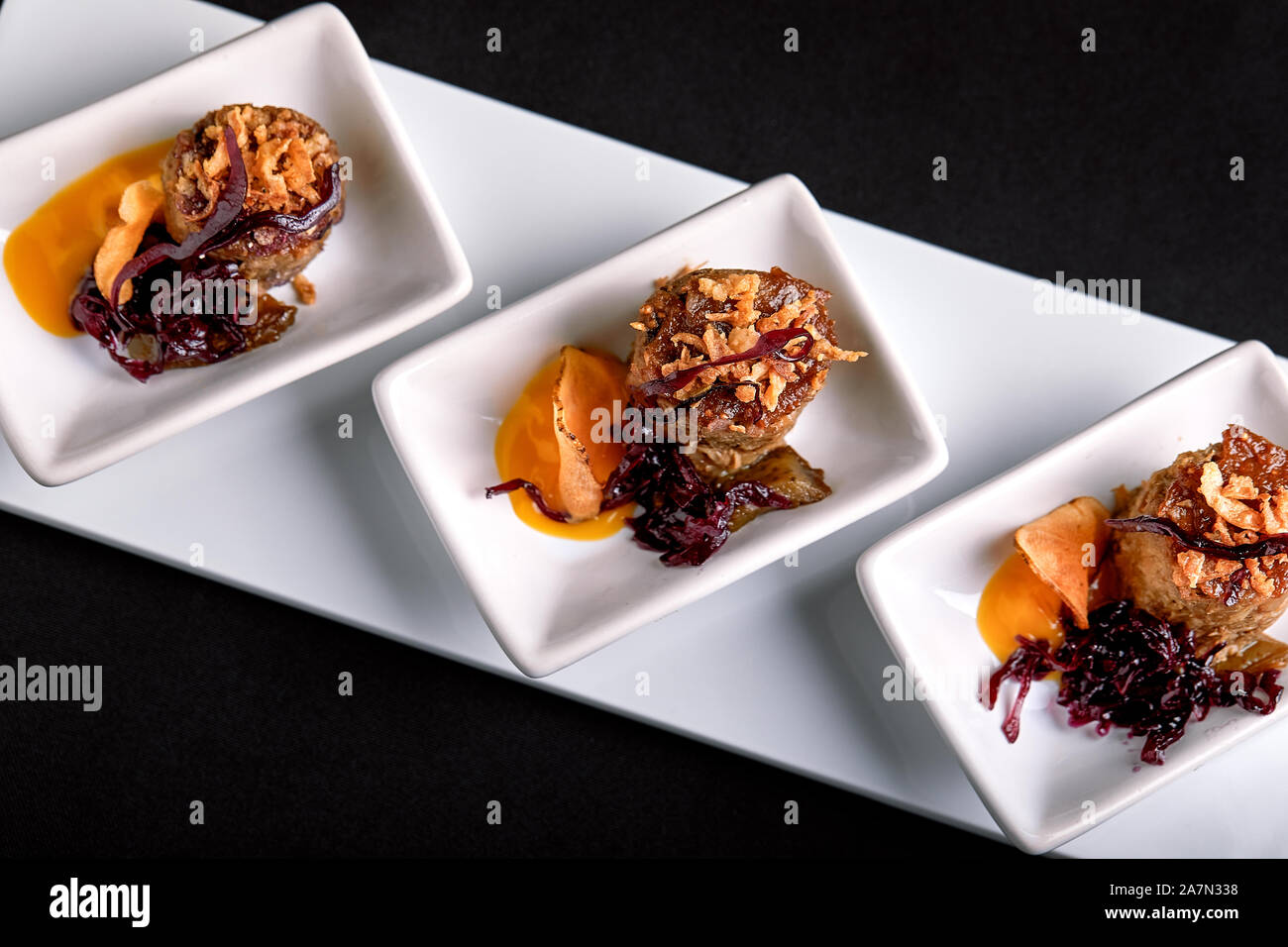 Canapes beef rolls with pumpkin sauce, on white plates Stock Photo - Alamy
