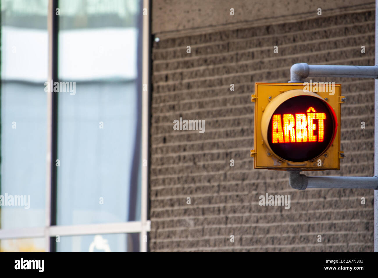 A French-language traffic light mounted on the side of a building ...