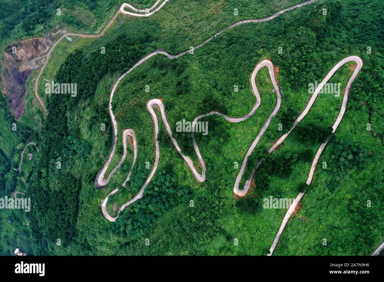 Aerial view of a winding mountain road resembling jade belt around the ...