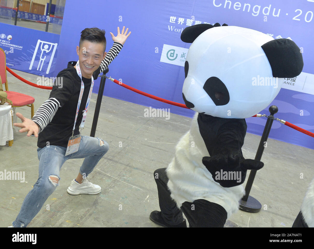 A guest interacts with a Chinese worker dressed in giant panda costume ...