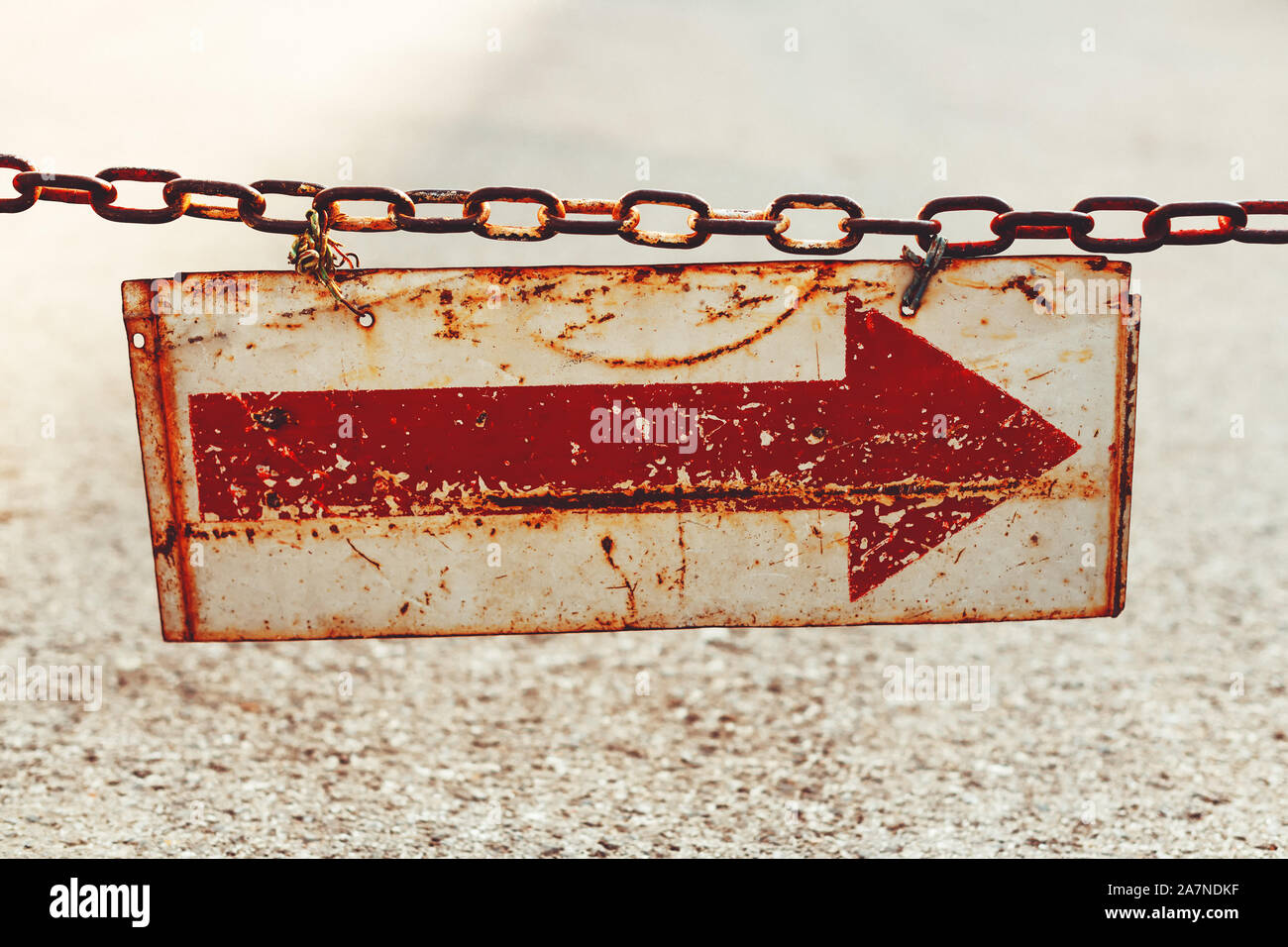 Worn red direction arrow sign pointing to right side Stock Photo - Alamy