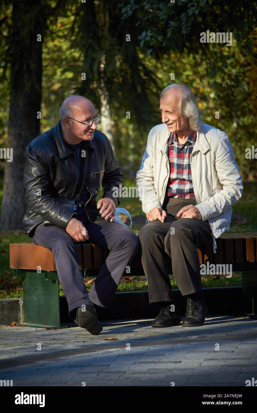 Two old men talking on a bench hi-res stock photography and images - Alamy