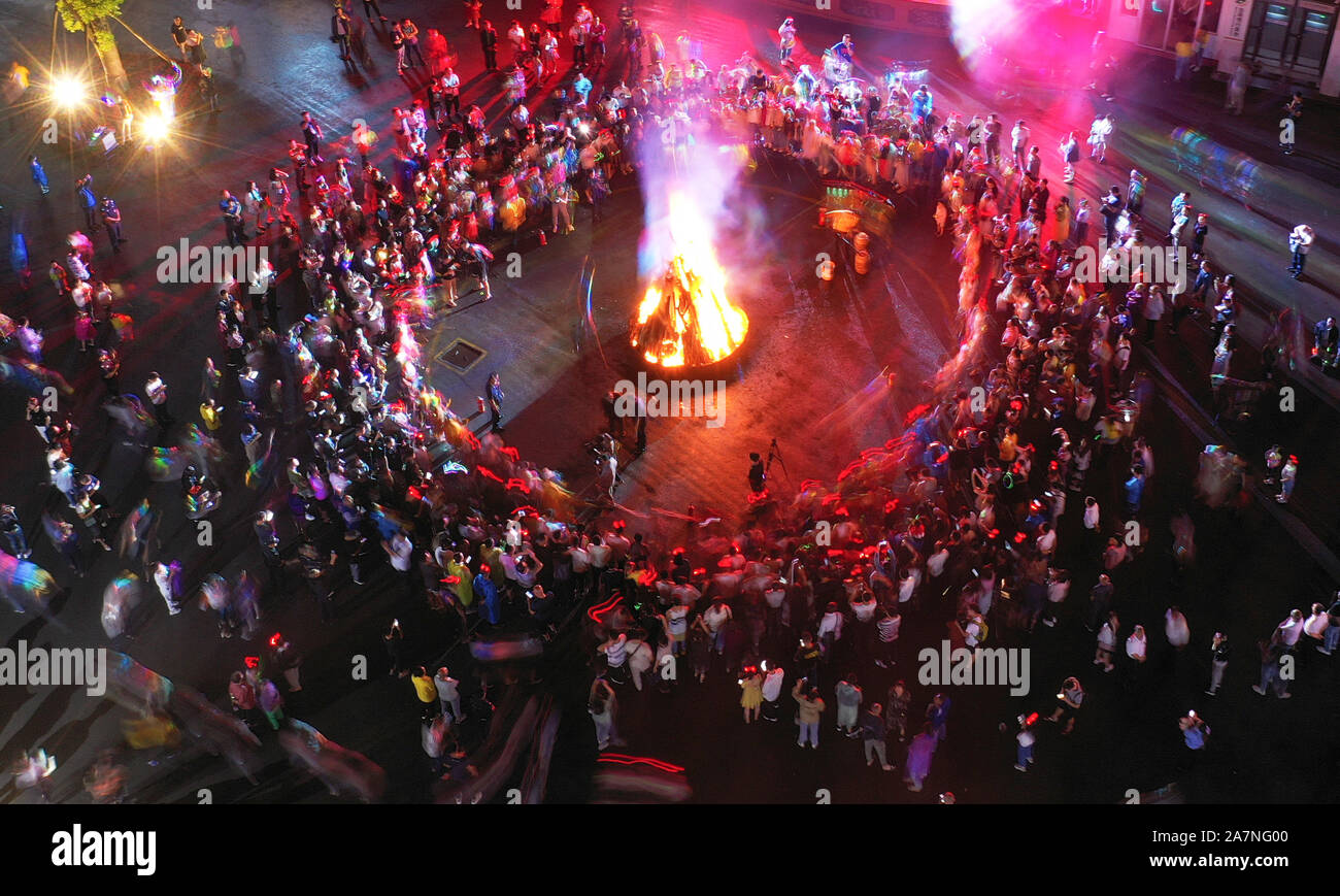 Local residents and tourists gather at a bonfire party during a music ...