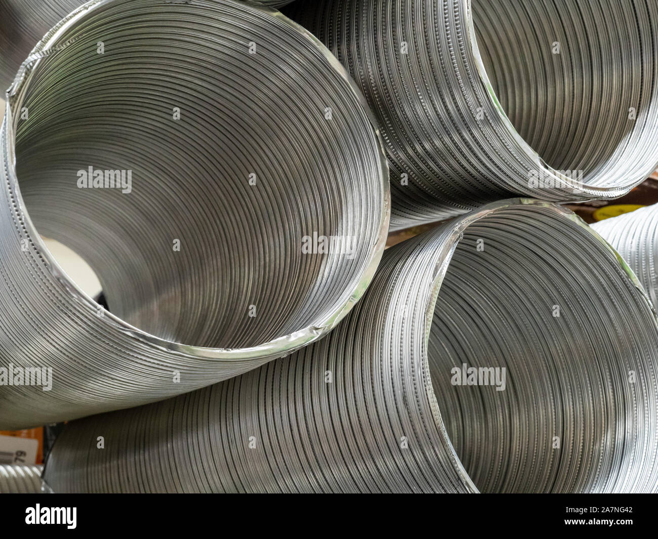 Aluminum duct sections sitting on top of each other in indoor storage ...