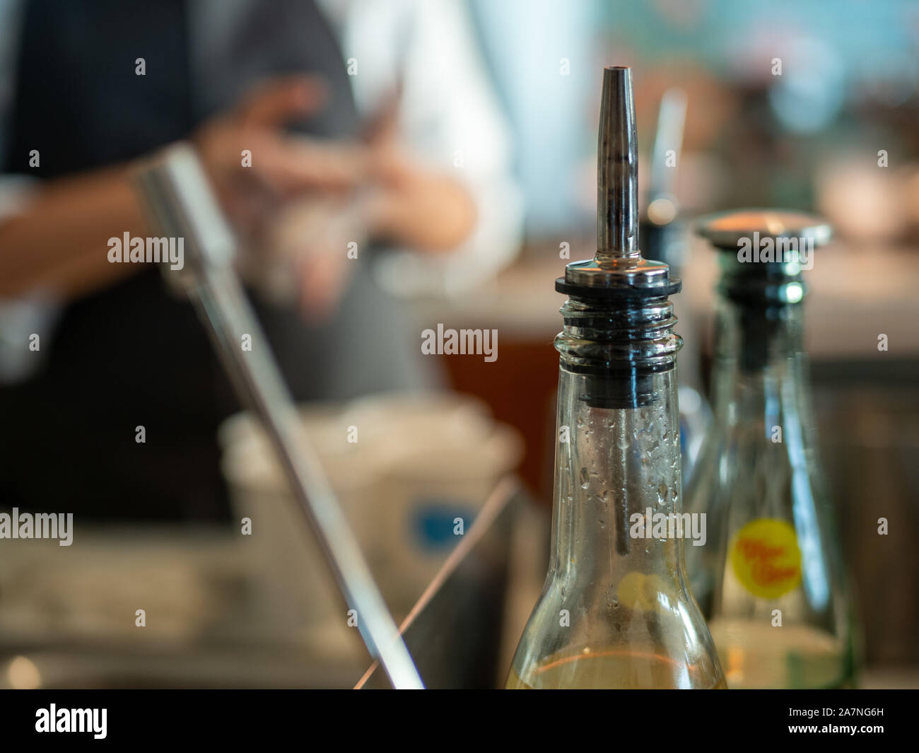 Nozzle of juice bottle sitting on counter of coffee shop with barista ...