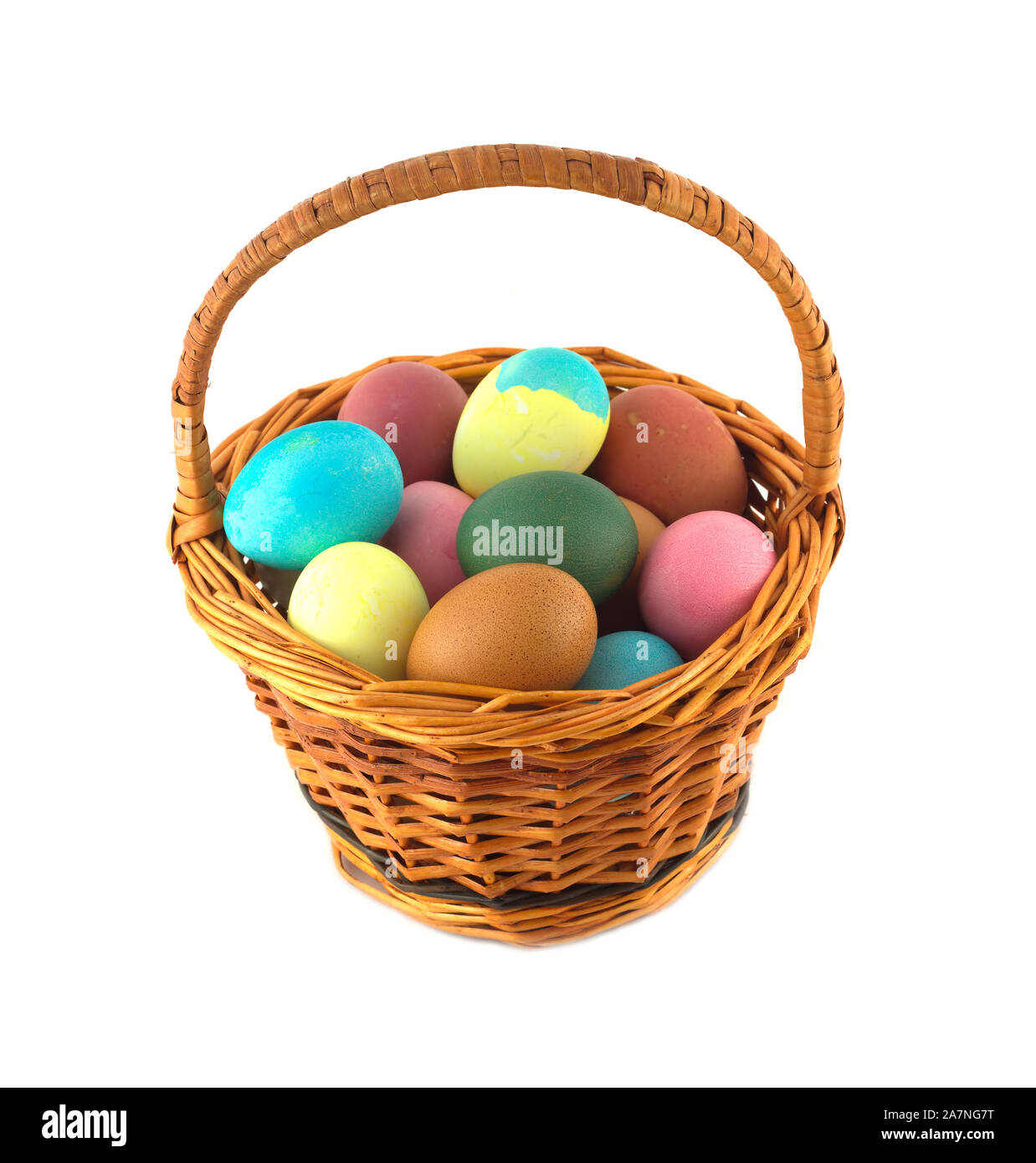 Colorful Easter eggs inside straw wicker brown basket isolate on white ...