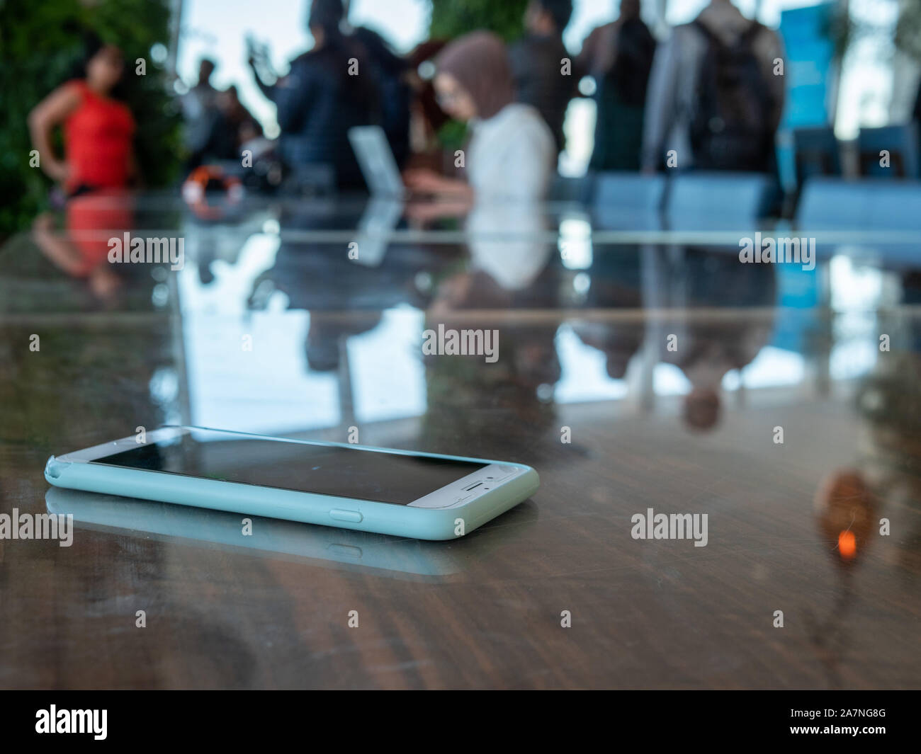 Cell phone with weathered case resting on table of a busy shop Stock ...
