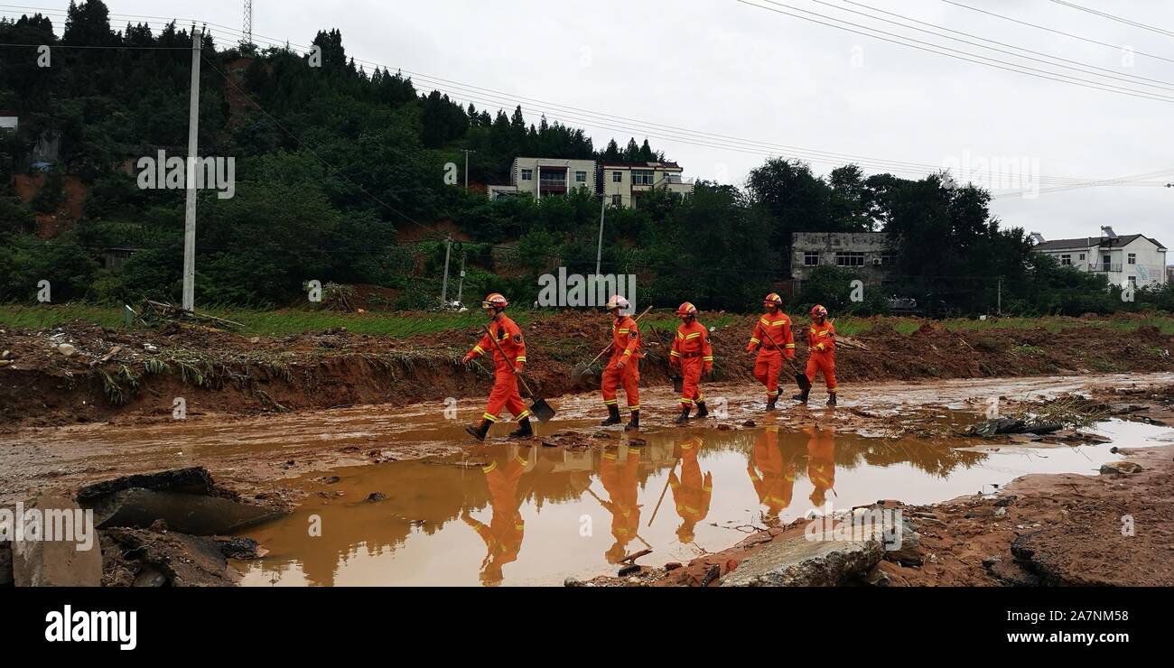 Chinese rescuers walk on a road covered with mud and stones after heavy ...
