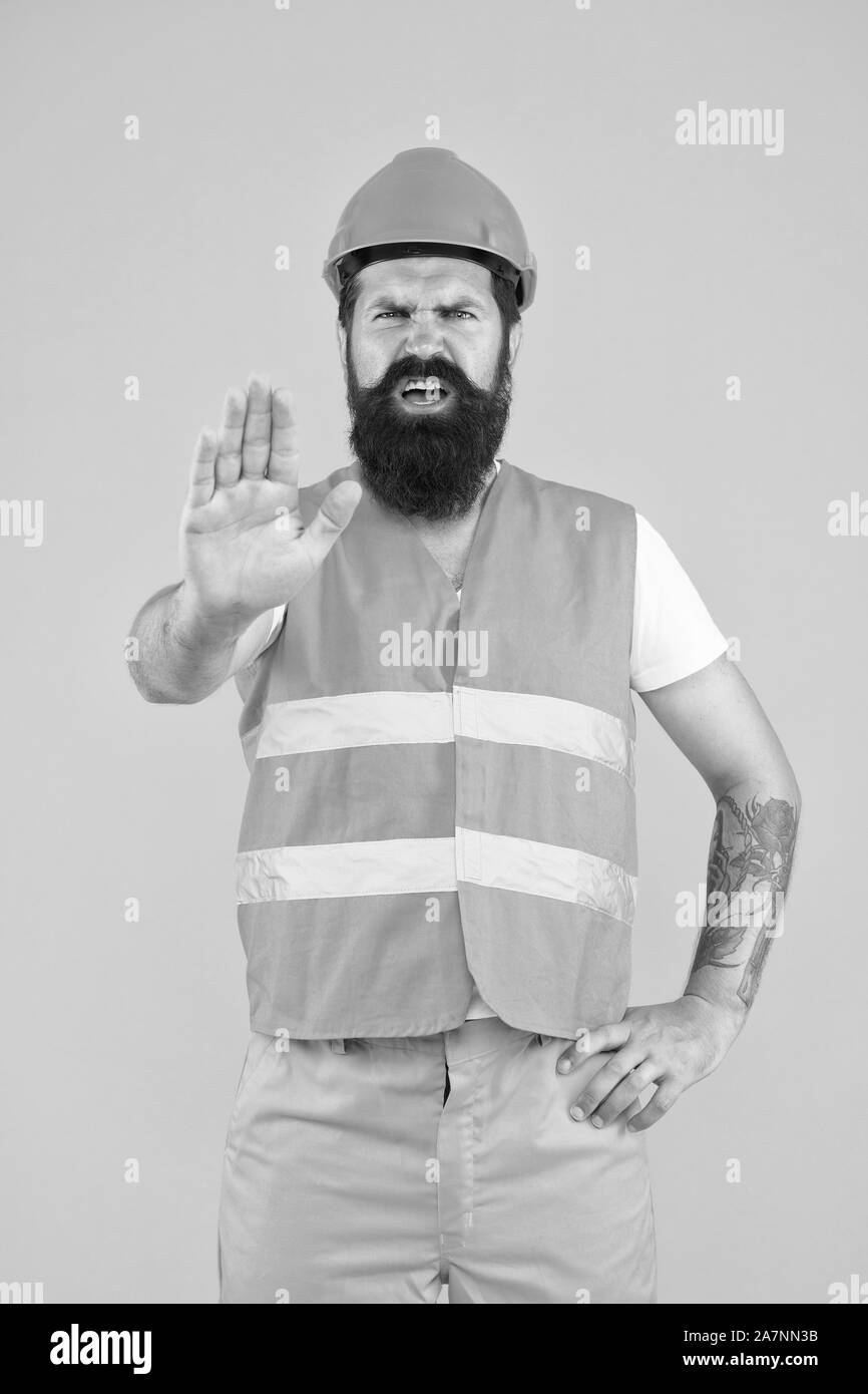 Caution, under construction. Hard worker showing caution sign on yellow ...