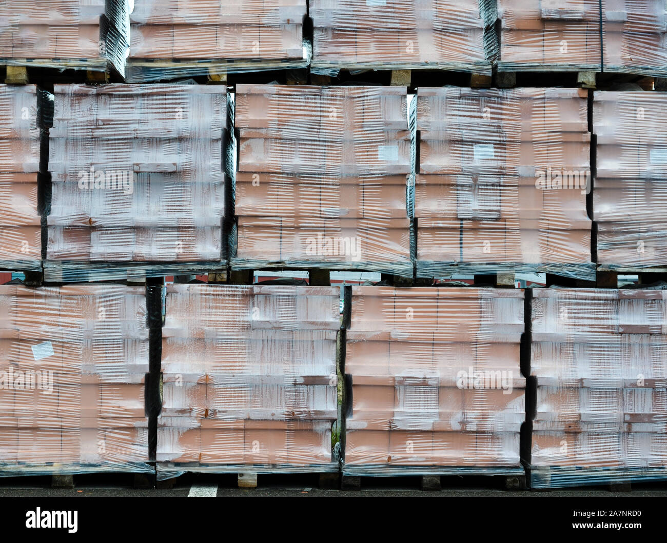 Brick packages packed in plastic foil outside next to the building ...