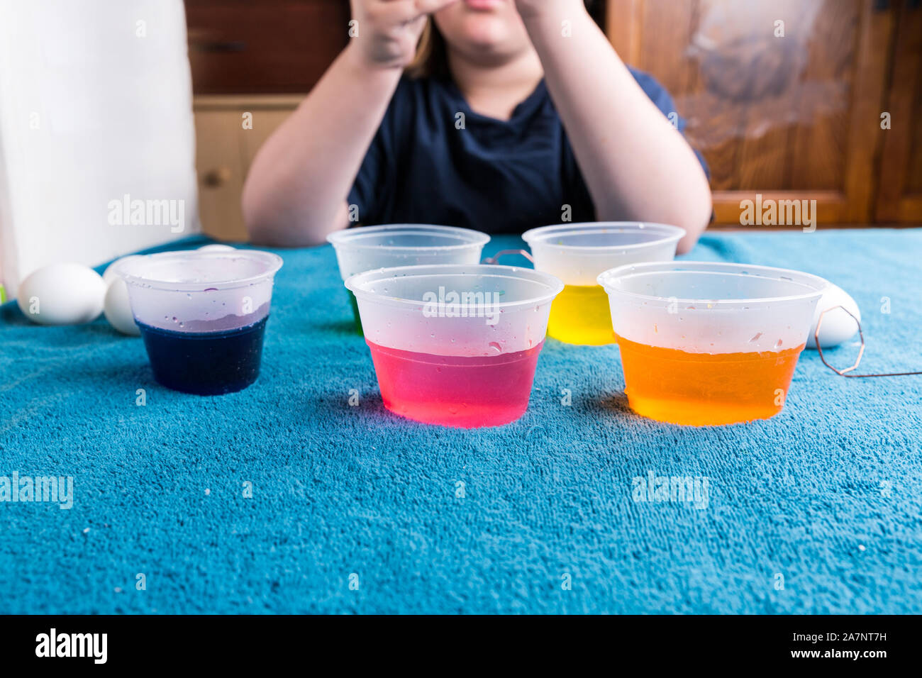 Child waiting for dye tablets to dissolve for easter egg dyeing Stock ...