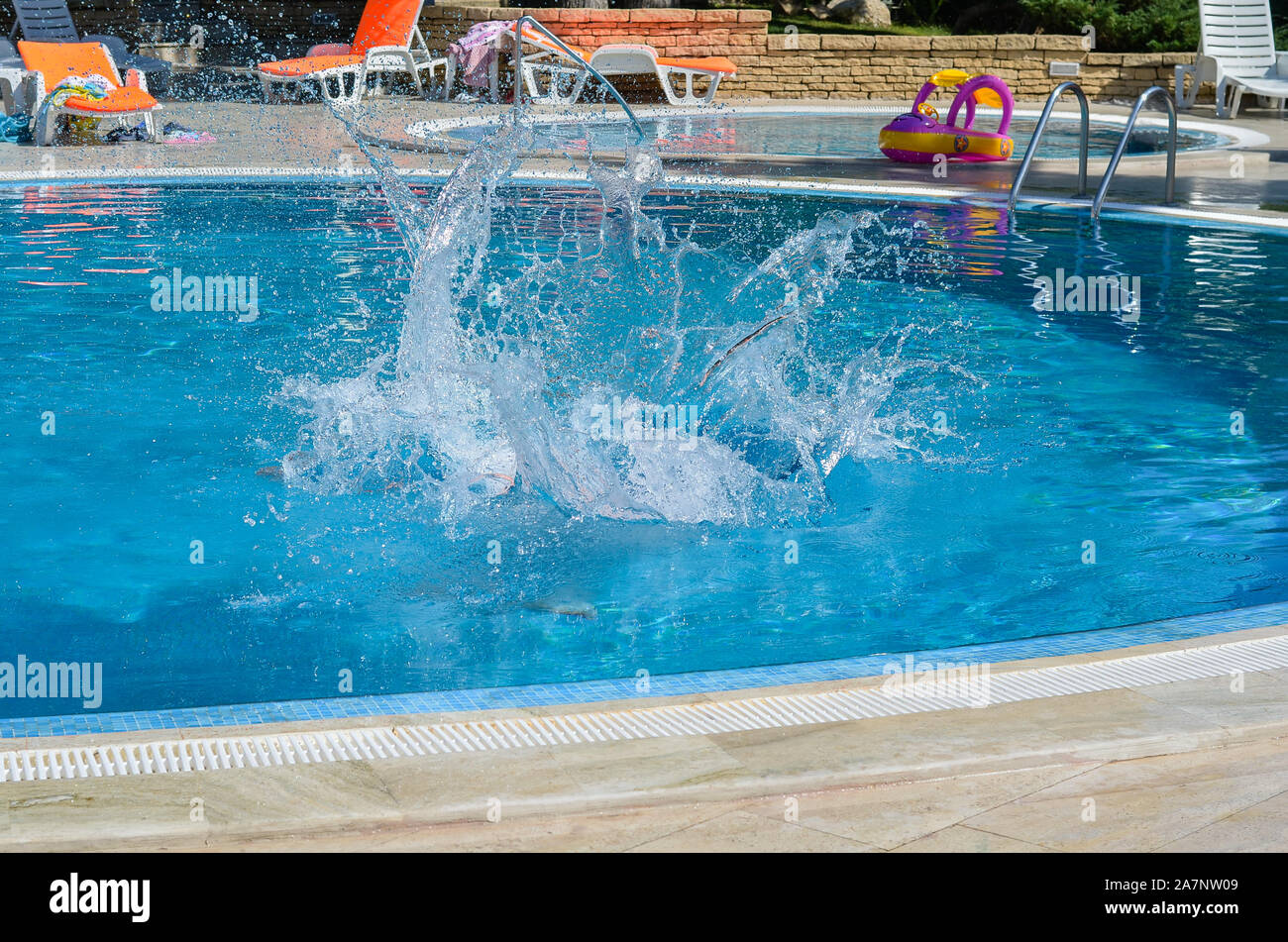 Splash of water in swimming pool during summertime Stock Photo - Alamy