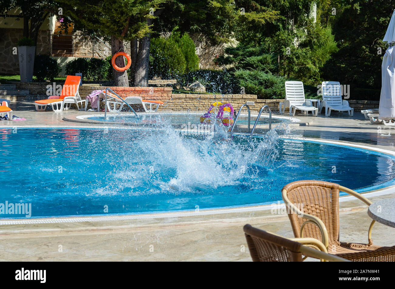 Splash of water in pool after dive during summer Stock Photo - Alamy