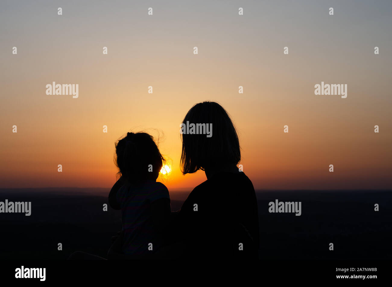 Mom and daughter relaxing at sunset Stock Photo - Alamy