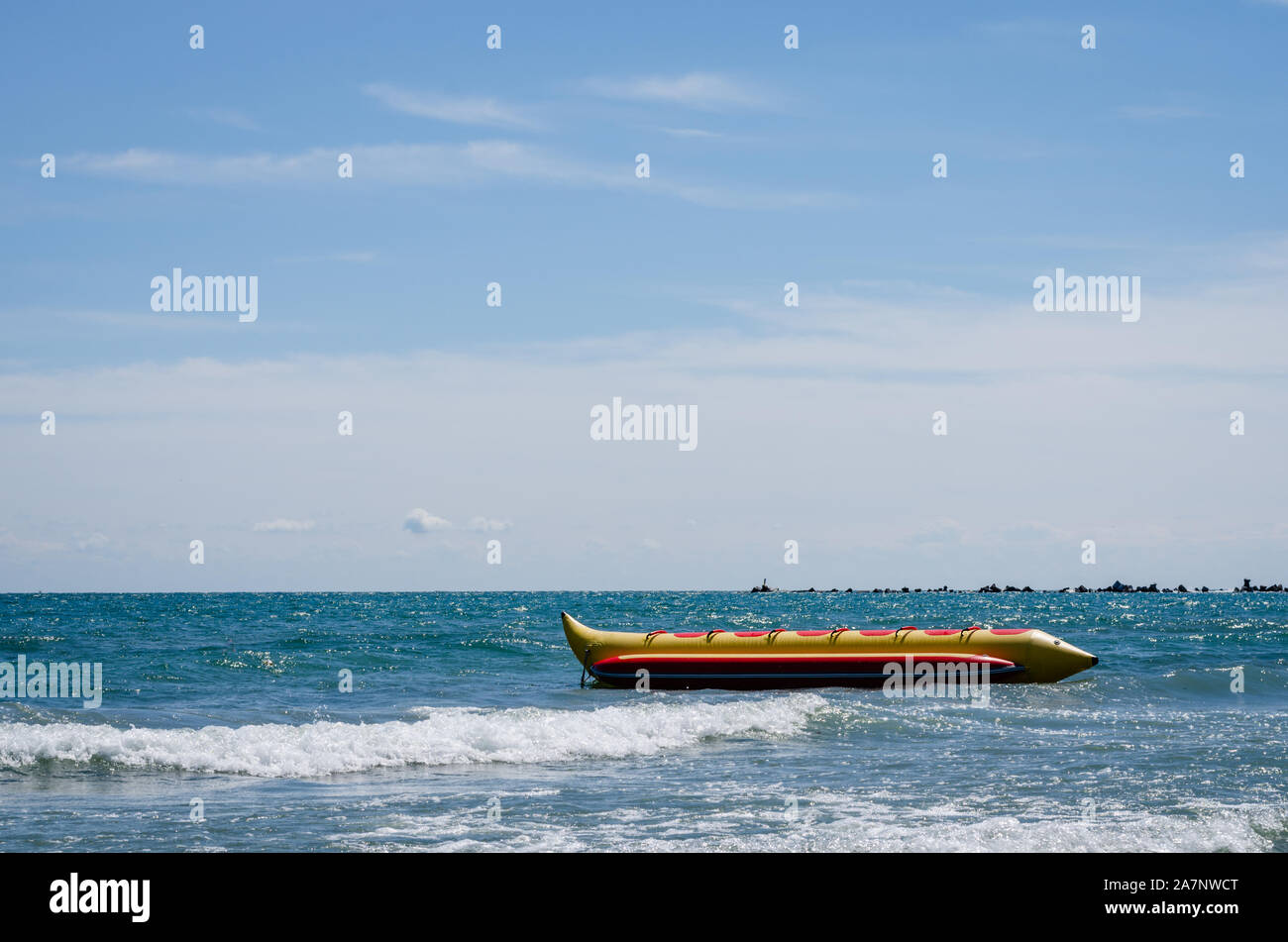 Floating yellow banana boat ride near seashoire ready to be used for ...