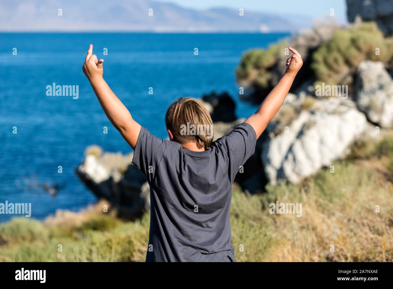 Child makes rude flip off gesture at camera at lake Stock Photo - Alamy