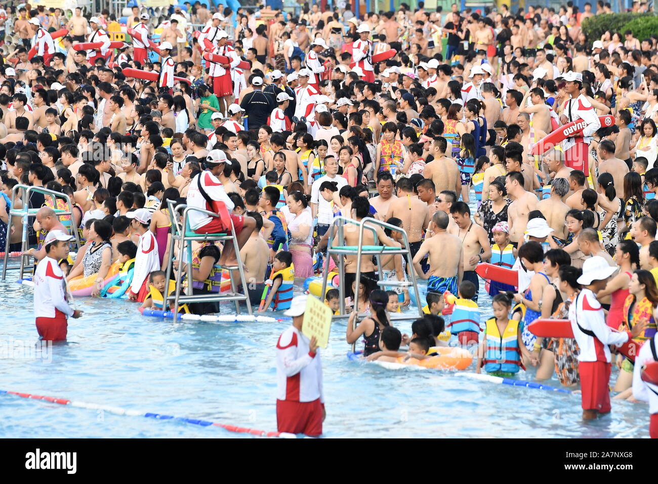 Tourists crowd a swimming pool at the Chimelong Water Park to cool off ...