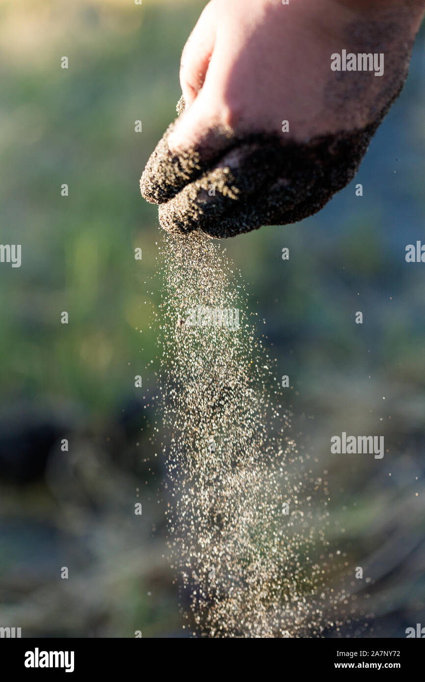 Sifting sands falling from a childs hand Stock Photo - Alamy