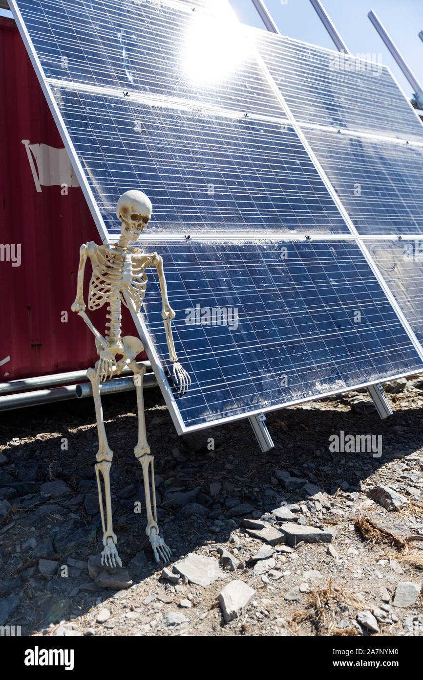 Skeleton leaning on solar panels in the desert Stock Photo - Alamy