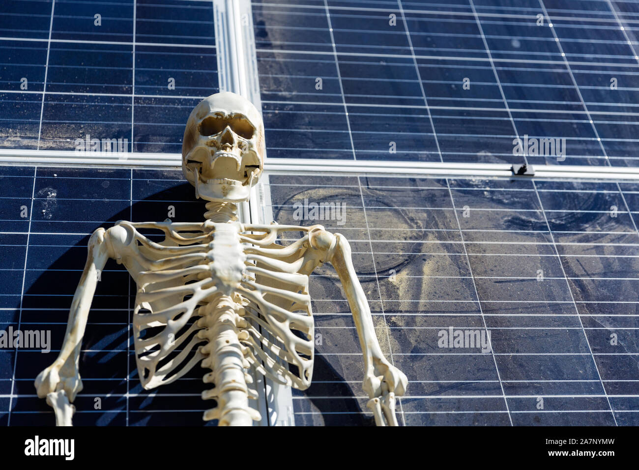 Skeleton leaning on solar panels in the desert Stock Photo - Alamy