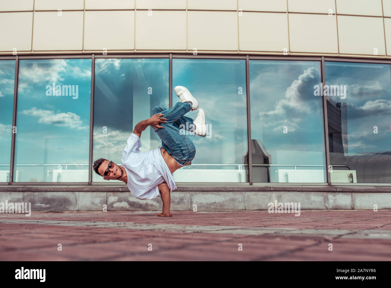Strong man acrobat dancer, dancing breakdance, summer city, free space ...
