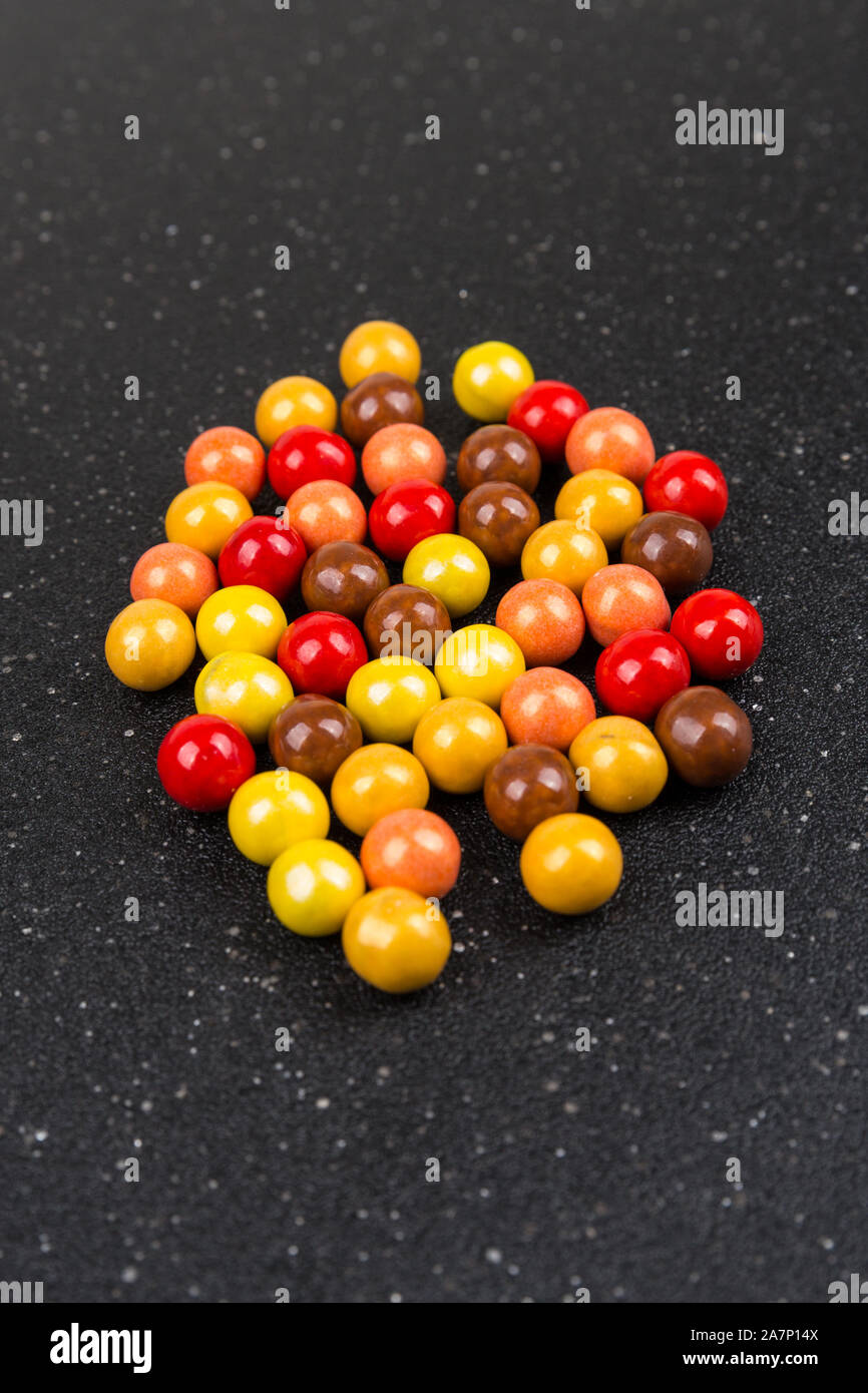 Sweet round fall colored chocolate covered candy balls Stock Photo - Alamy