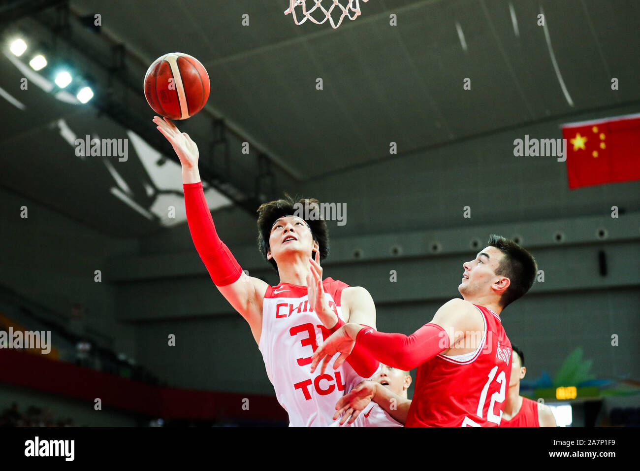 Wang Zhelin, a Chinese professional basketball player, left, jumps for ...