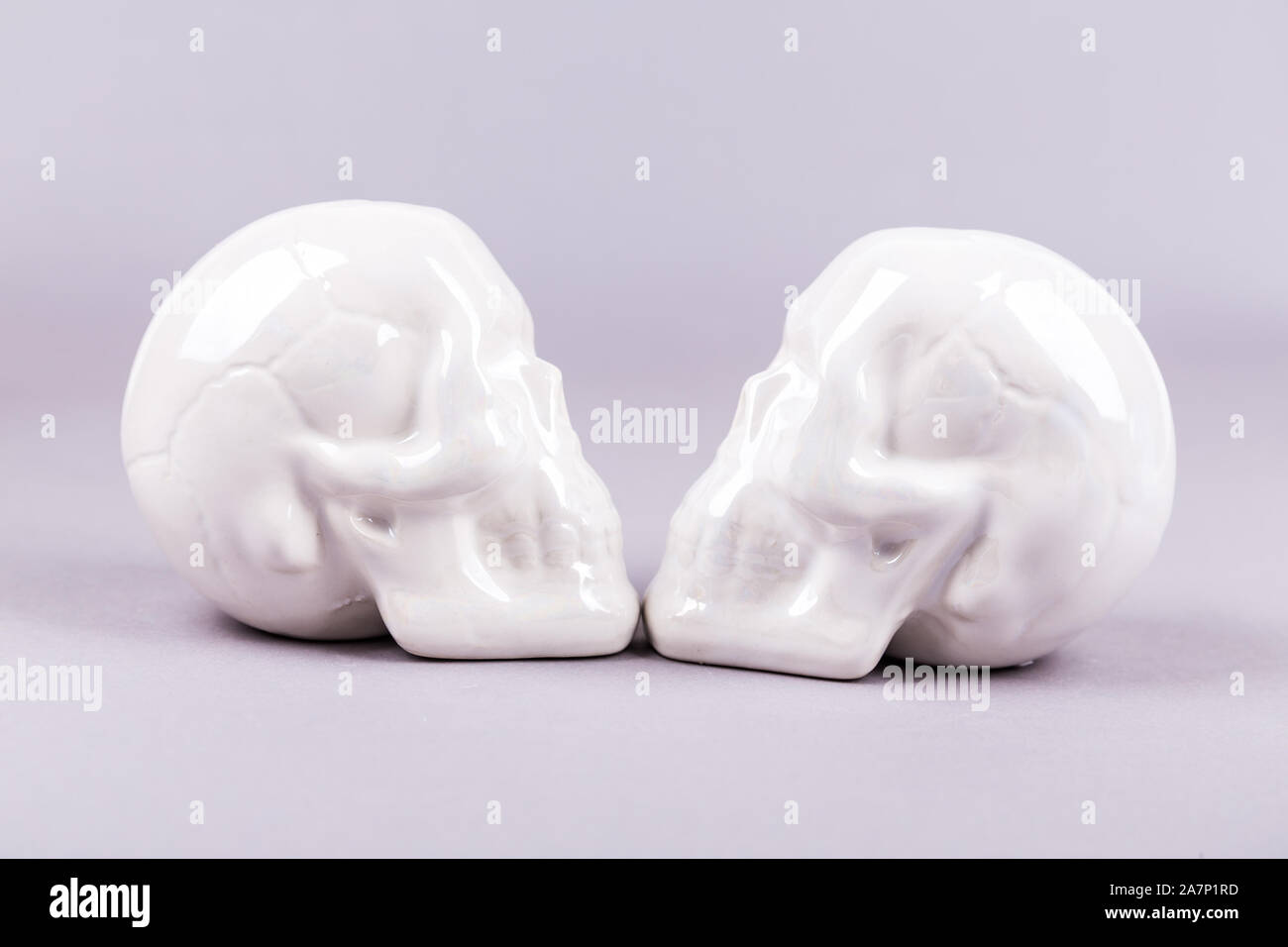 White shiny ceramic skull figures on a blank background Stock Photo - Alamy