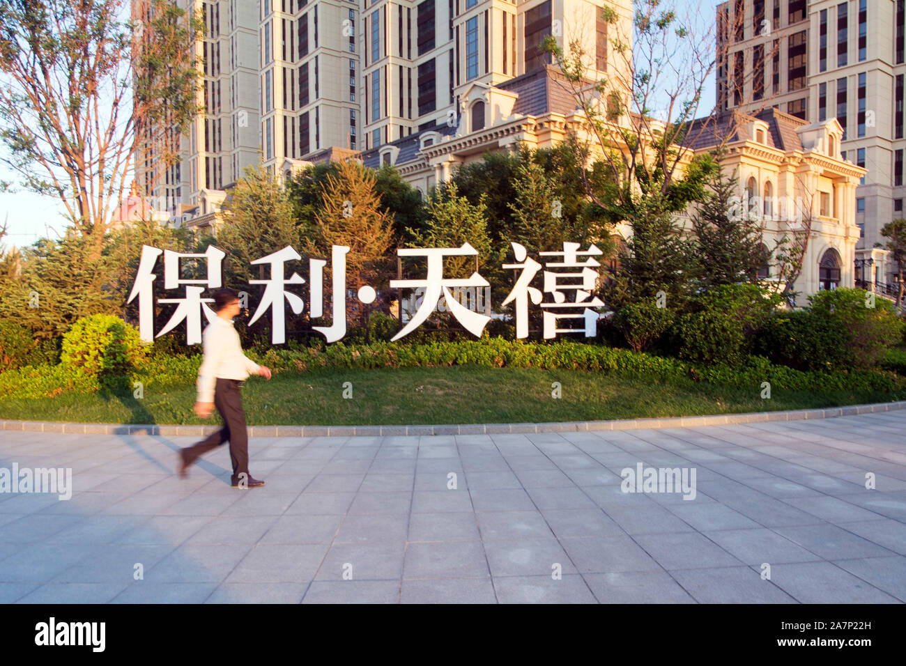--FILE--A local resident walks past an apartment project of Poly ...
