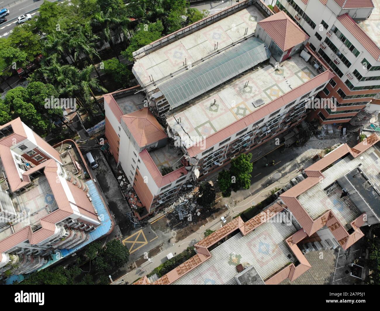 An aerial view of a department building tilted and collapsed near a ...