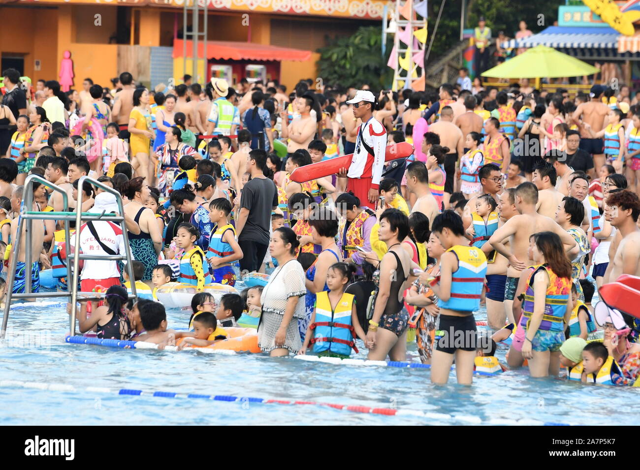 Tourists crowd a swimming pool at the Chimelong Water Park to cool off ...