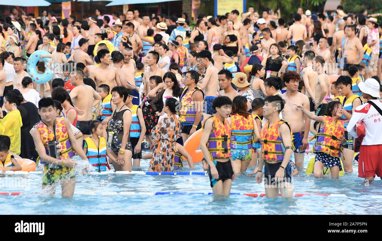 Tourists crowd a swimming pool at the Chimelong Water Park to cool off ...