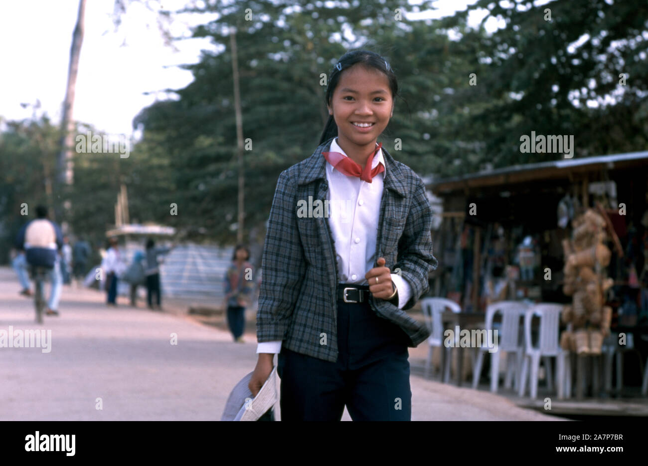 A young, indigenous Mnong (Pnong) girl walks through her village on her ...