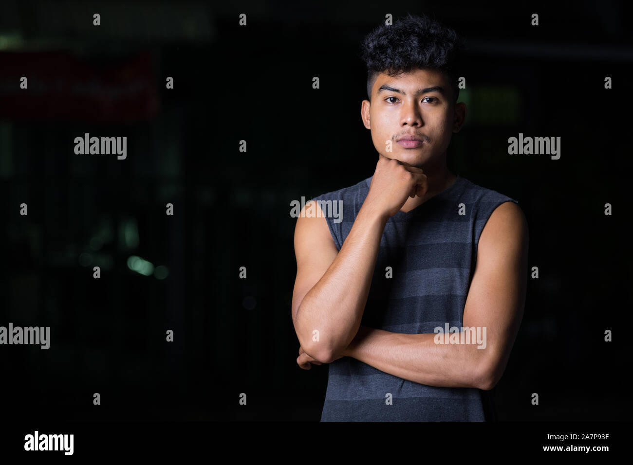 Young Asian man thinking and looking at camera at night outdoors Stock ...