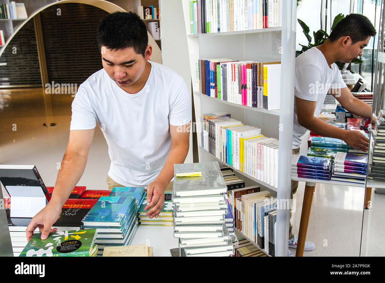 A Chinese worker displays books in the 52nd-storey Duoyun Bookstore ...