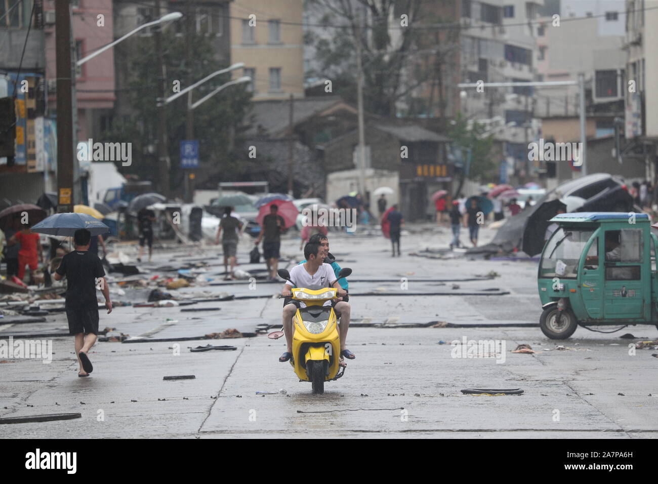A cyclist rides on a flooded road after heavy rainstorm caused by ...