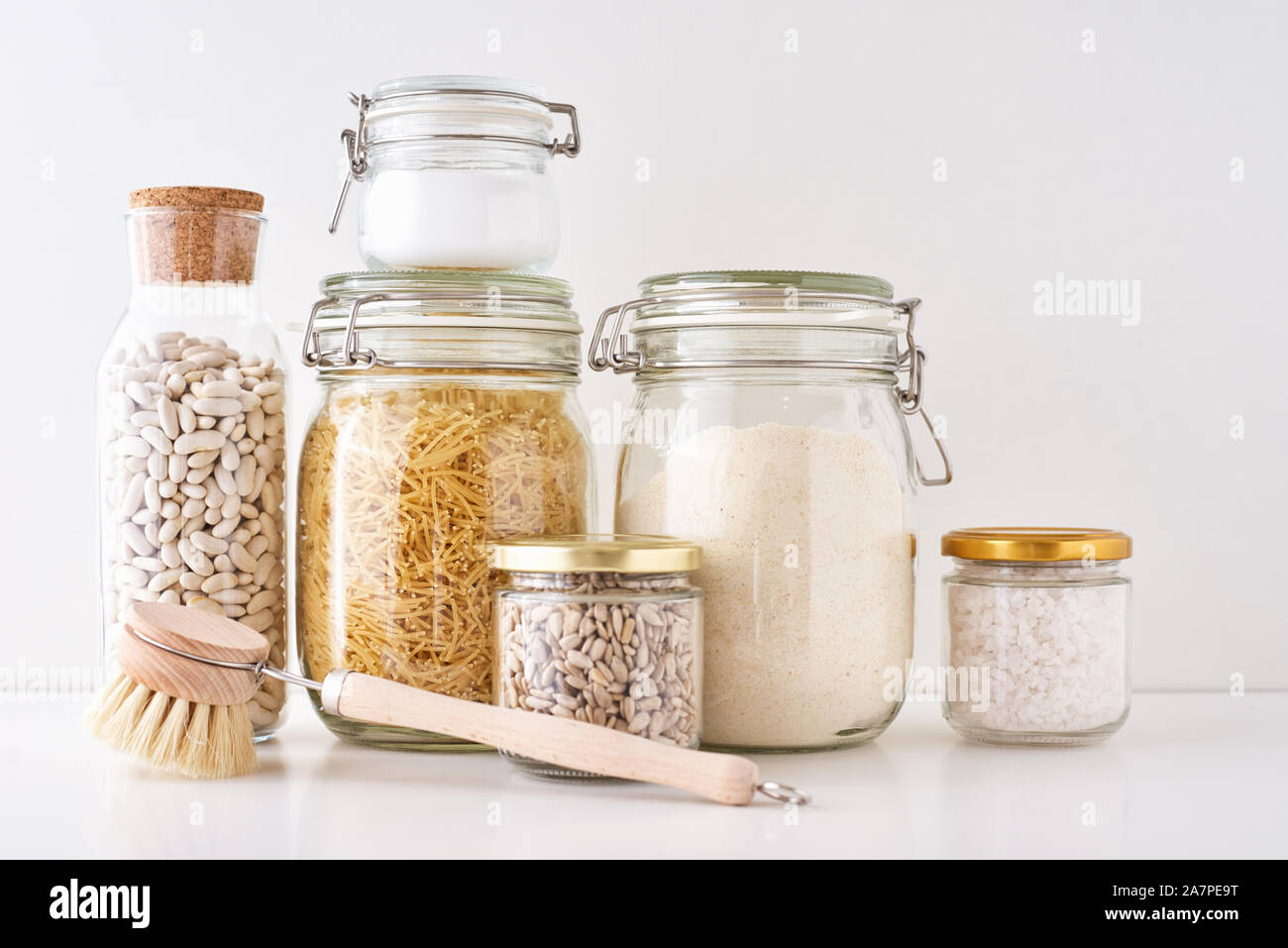 Glass jars with food ingredients on white background. Zero waste ...