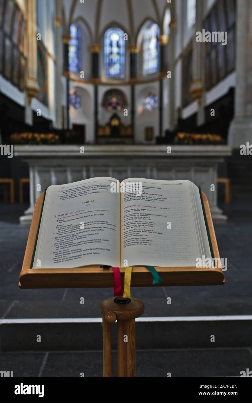 Book page of the day in front of altar in church Stock Photo - Alamy