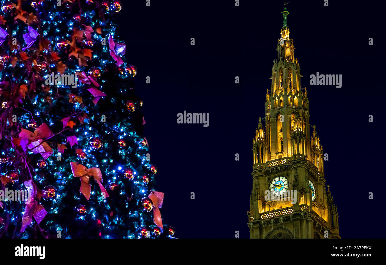 Christmas tree with The illuminated clock tower of city hall - rathaus ...