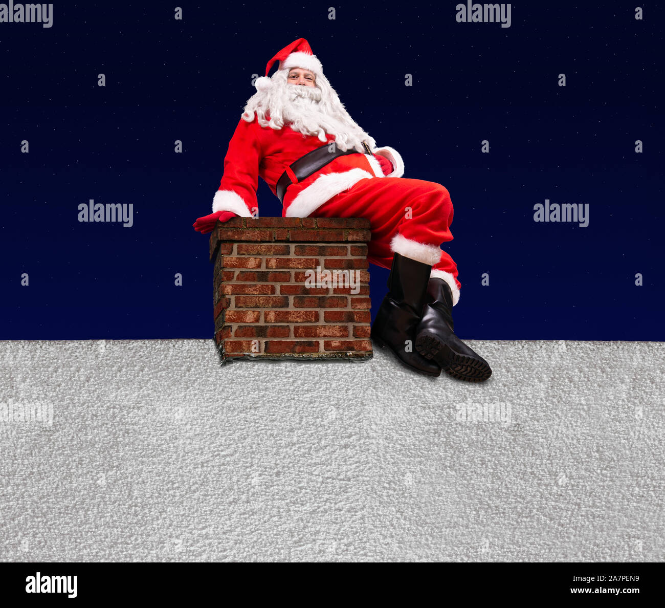 Santa Claus sitting on the chimney at a snowy roof of house, background ...