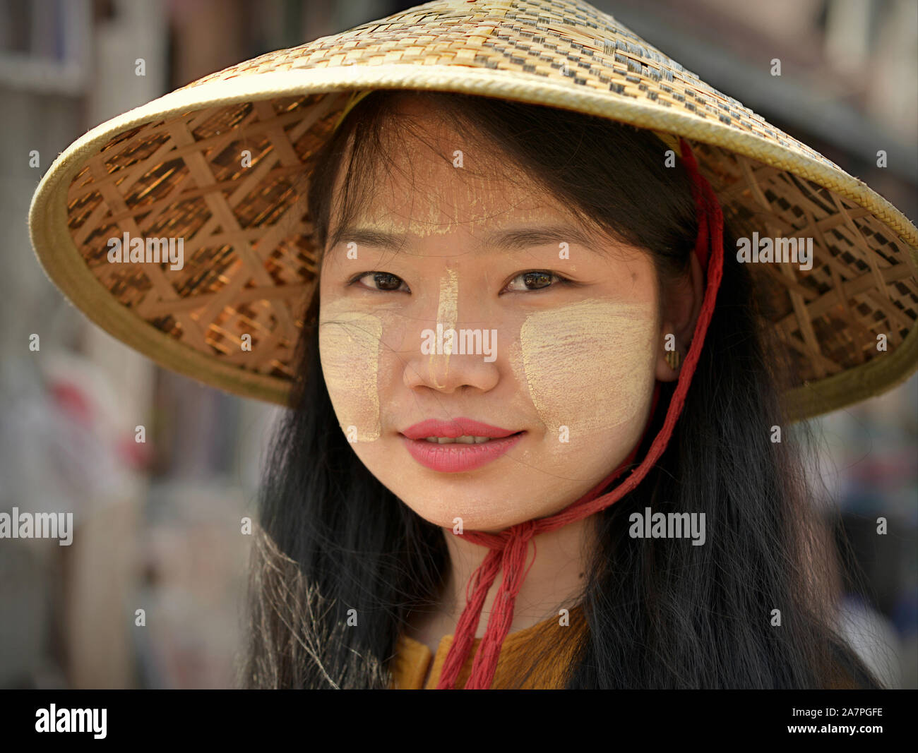 Young Burmese woman with patches of traditional thanaka face cosmetic ...