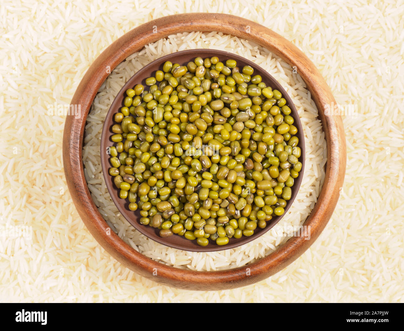 Rice in bowl and green gram in clay plate. Background from basmati rice ...