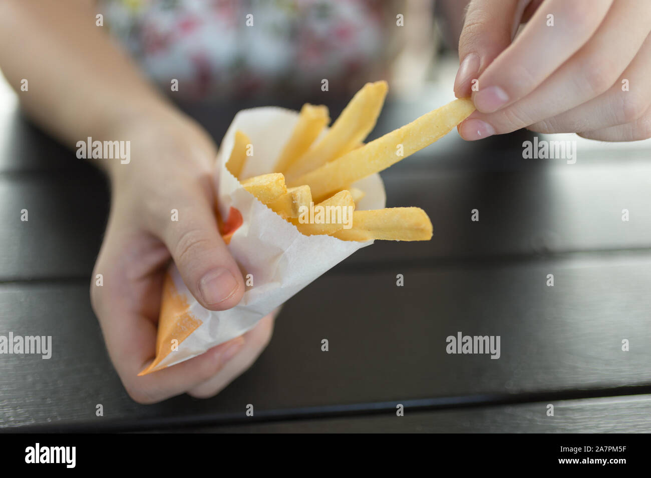 A close up portion of french fries in woman's hands Stock Photo - Alamy
