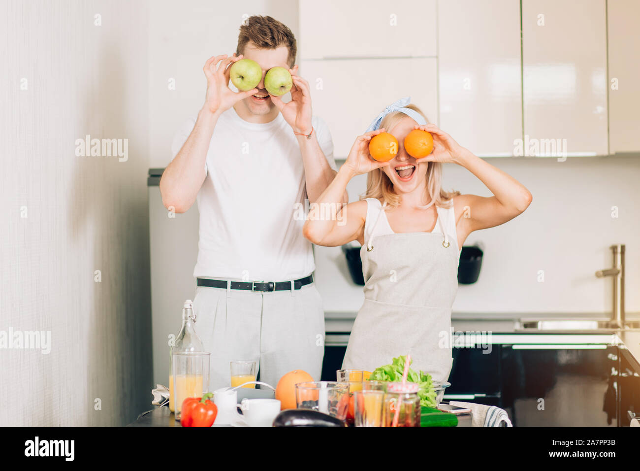 Romantic newly married couple cooking healthy food and having fun ...