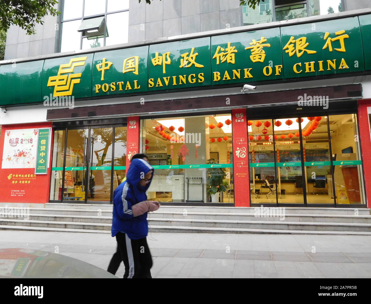 --FILE--Pedestrians walk past a branch of Postal Savings Bank of China ...