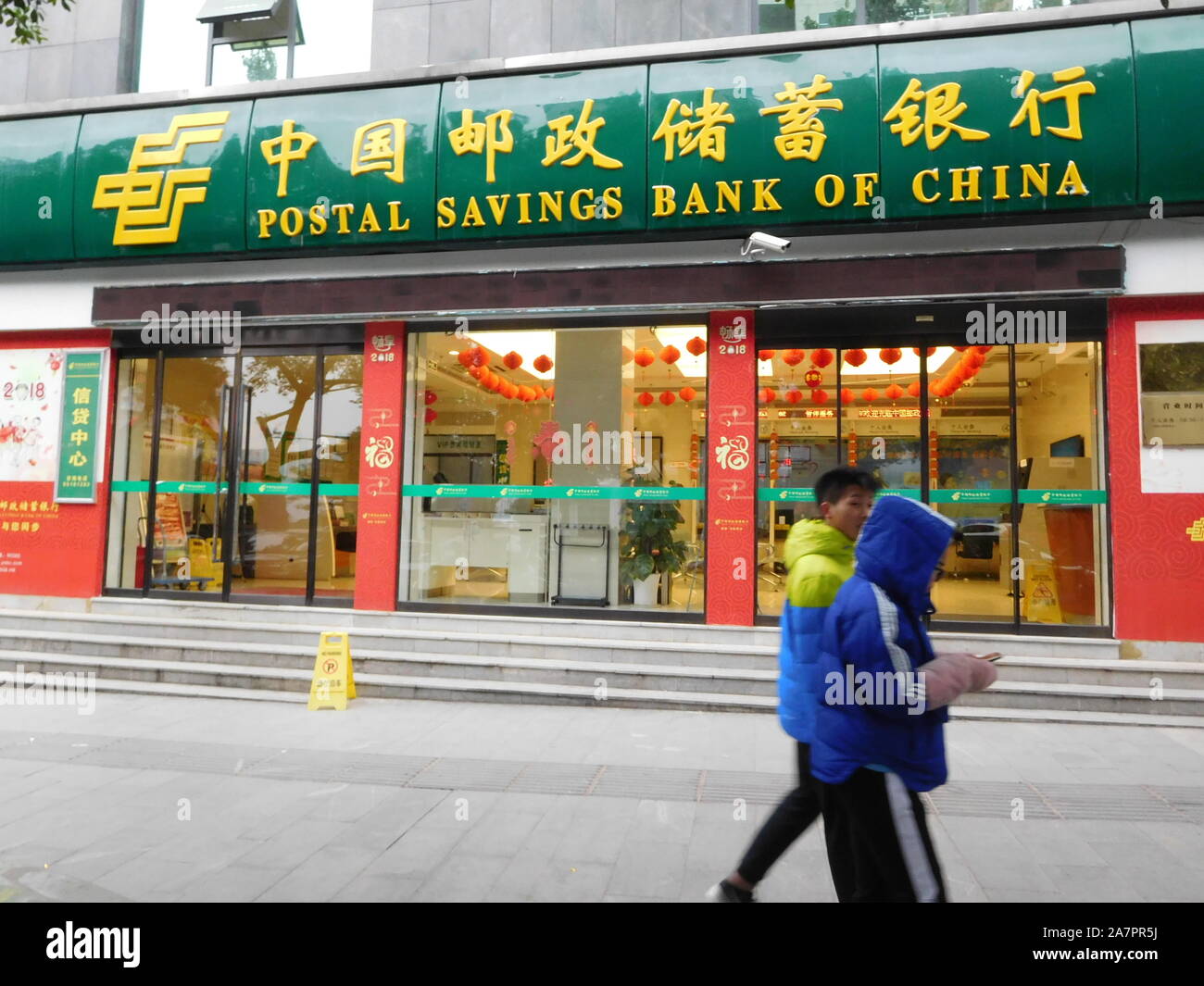 --FILE--Pedestrians walk past a branch of Postal Savings Bank of China ...