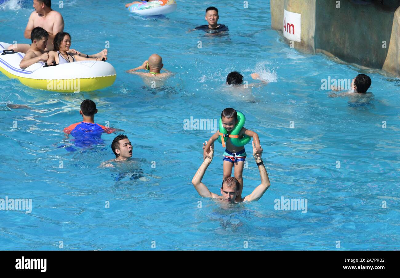 Chinese holidaymakers crowd a swimming pool at a water park to escape ...