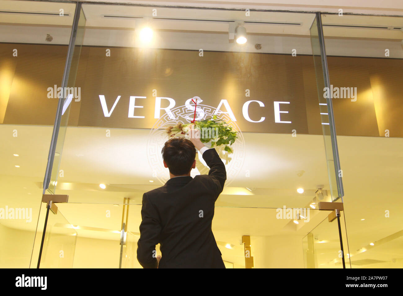 --FILE--A Chinese worker is seen in front of a fashion boutique store ...