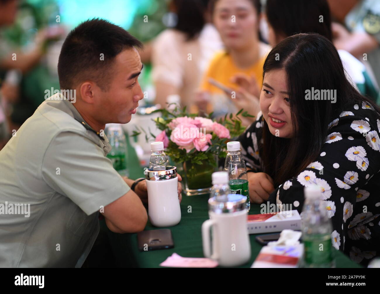Male police officers and females sit across the long table talking to ...