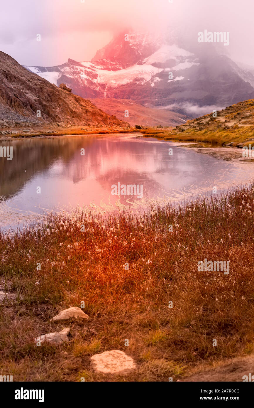 Colorful pink sunrise and reflection of Matterhorn mountain at ...